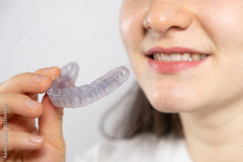 A woman holds dental mouthguard, splint for the treatment of ...