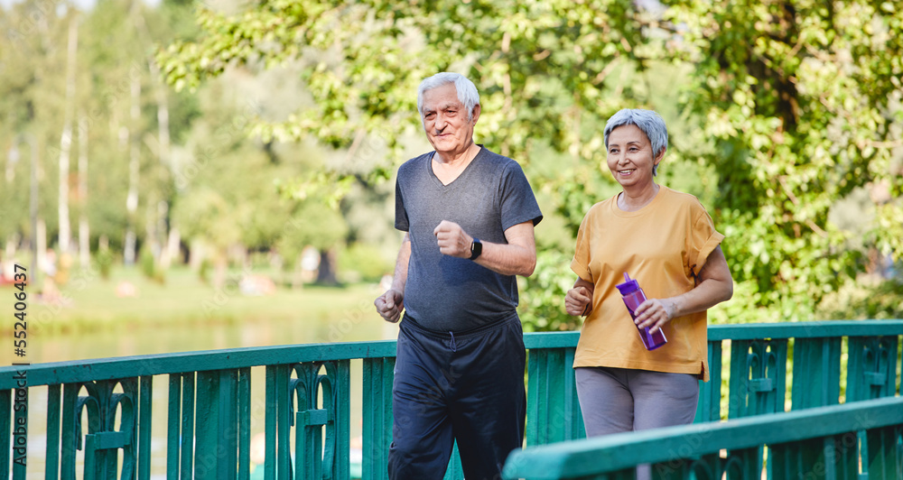 Senior couple jogging in the summer park.Older couple jogging in the ...
