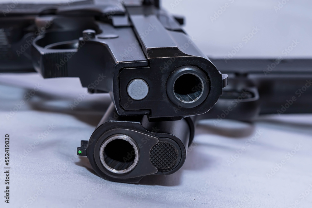 Two black pistols stacked on top of each other, a 40 caliber and a 45 ...