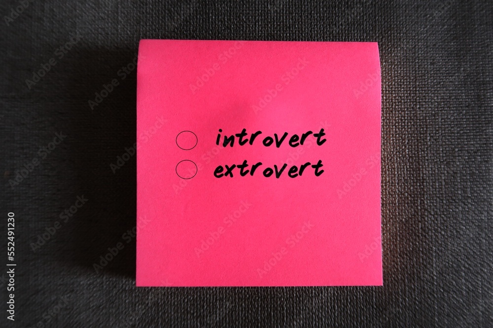 Bright pink note with text INTROVERT and EXTROVERT, Concept of ...