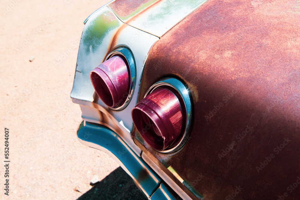 Vintage scene of red taillights on a rusty American car with a chrome ...