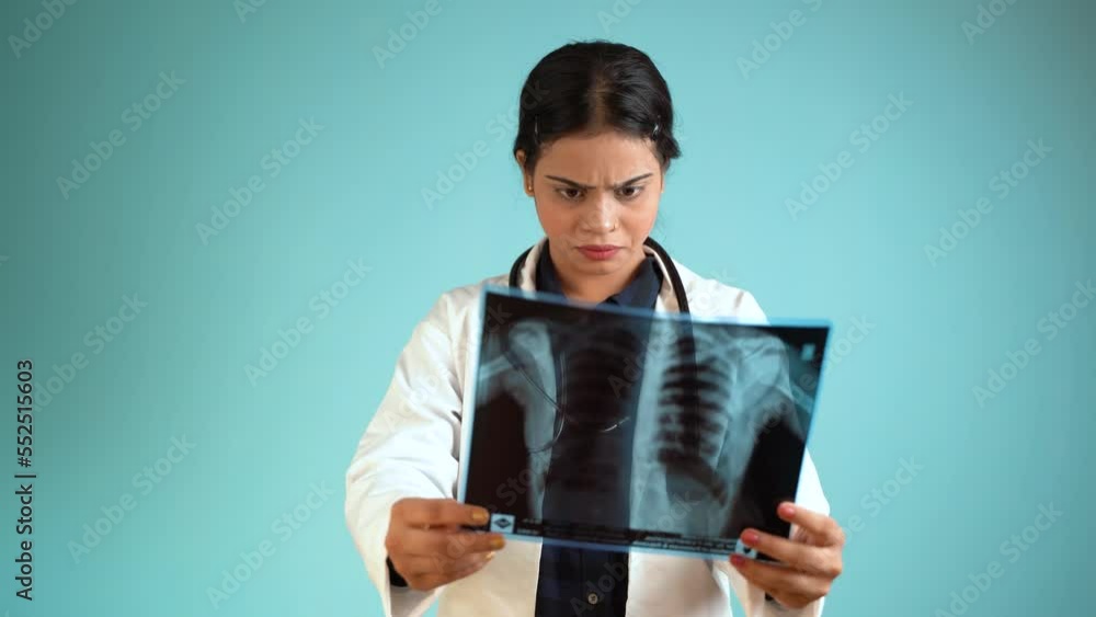 Portrait of a young female doctor examining patient's x-rays scan ...