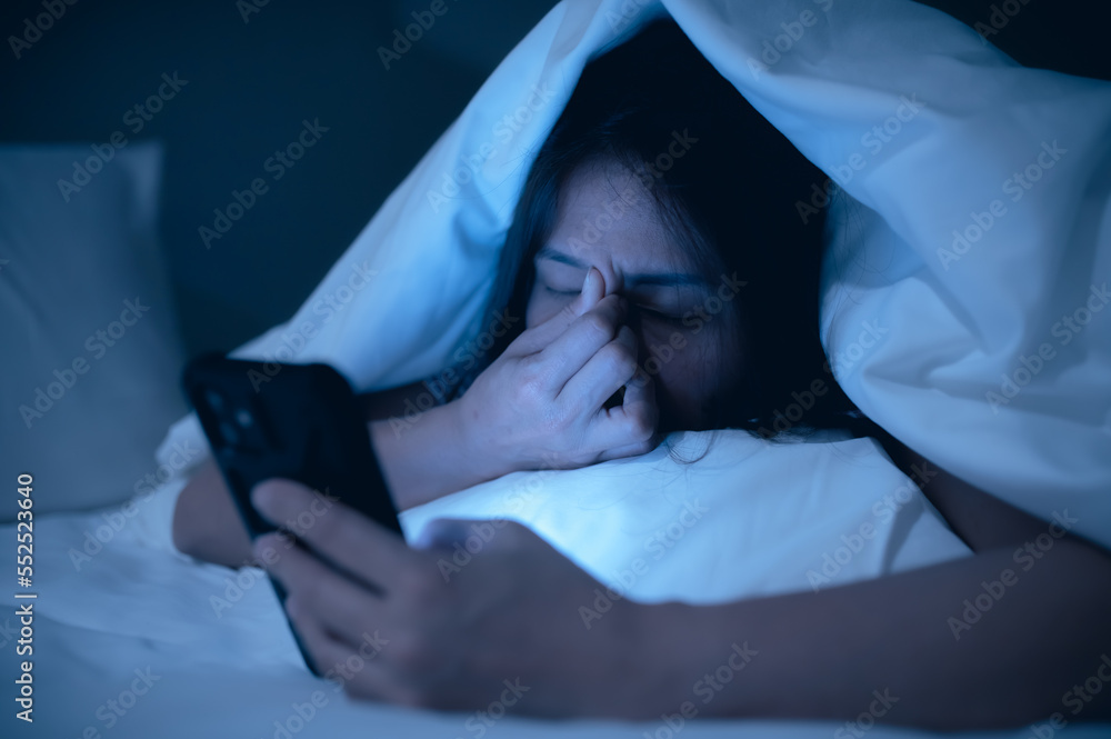Asian woman playing game on smartphone in the bed at night,Thailand ...
