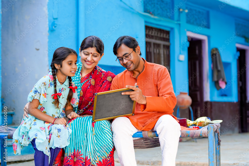 education concept : Indian parents teaching some detail to daughter at ...