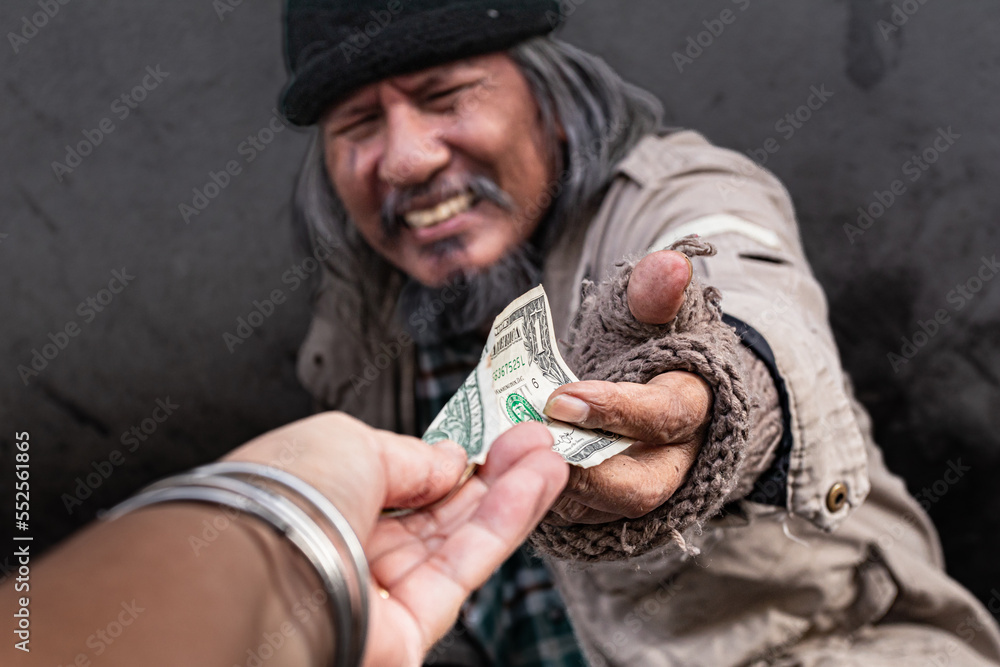 Selective focus of hand kind person giving one dollar bill money to old ...