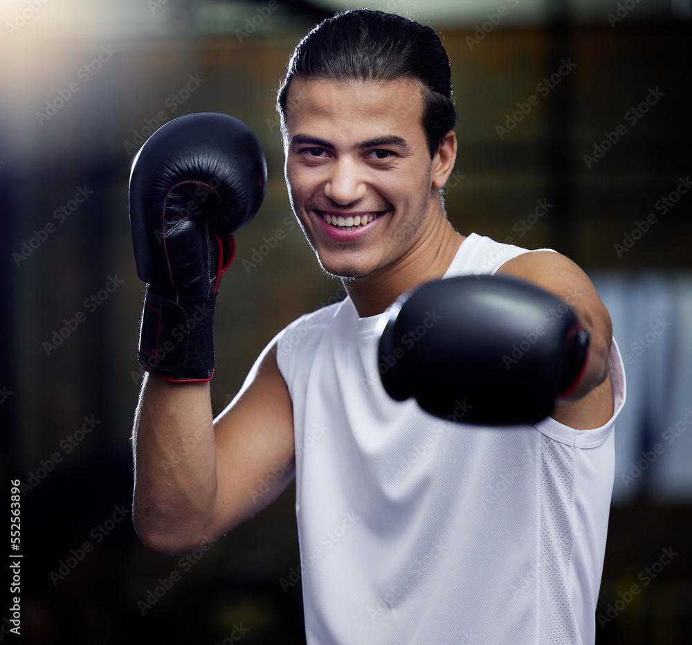 Portrait, fitness and boxing man punching with boxing gloves in a sport ...
