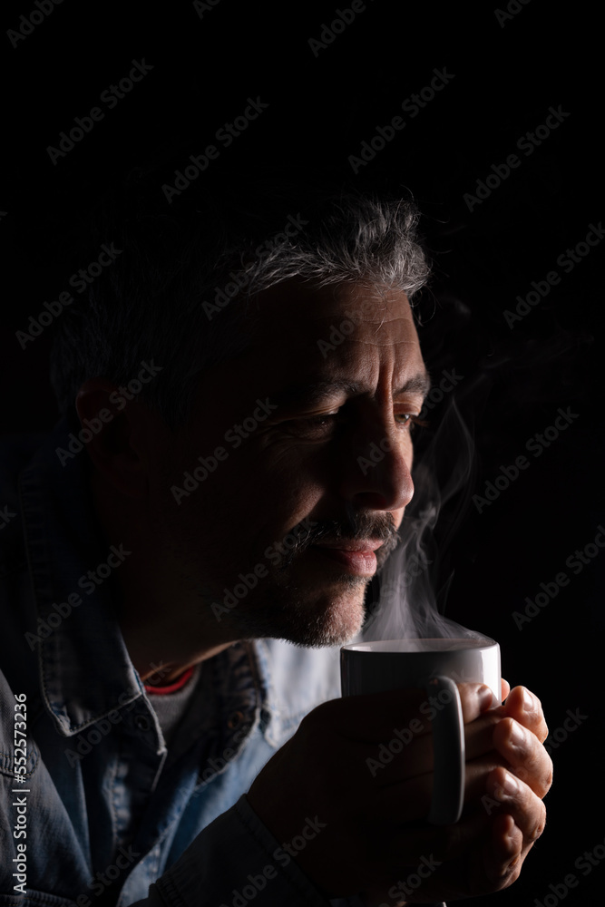 portrait d'un homme qui boit un café ou un thé. Il tient une tasse ...