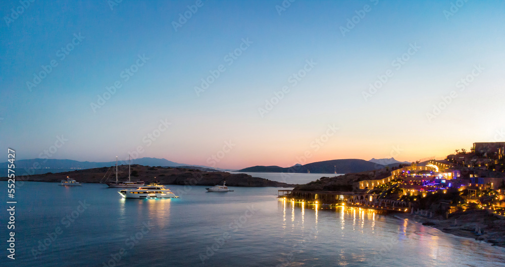 Night view to large illuminated boat near luxury resort, colorful ...