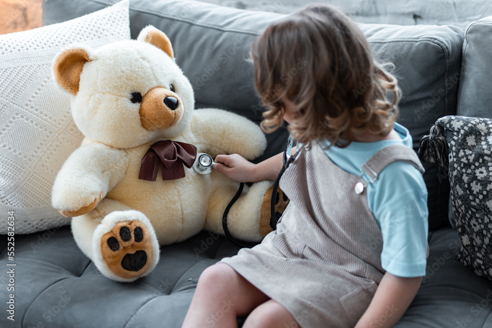 Cute little girl playing funny game being a doctor with her big fluffy ...