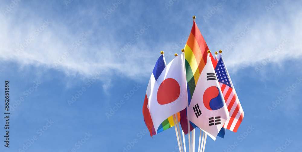 Isolated rainbow flags and flags of many countries, cloudy and bluesky ...