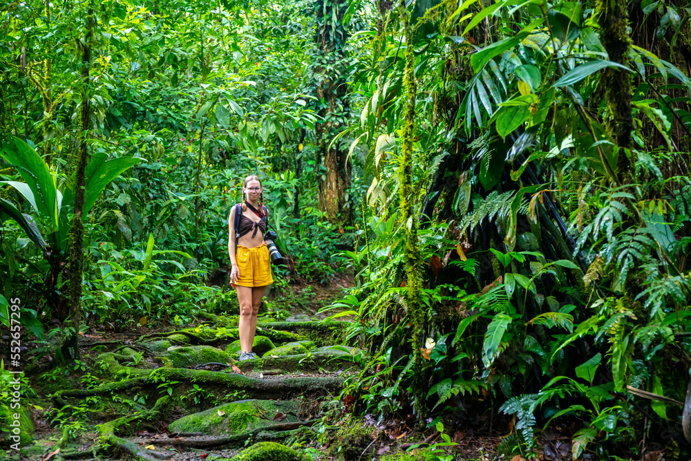 girl photographer walks through dense Costa Rican tropical rainforest ...