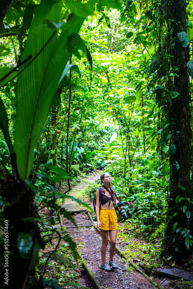 girl photographer walks through dense Costa Rican tropical rainforest ...
