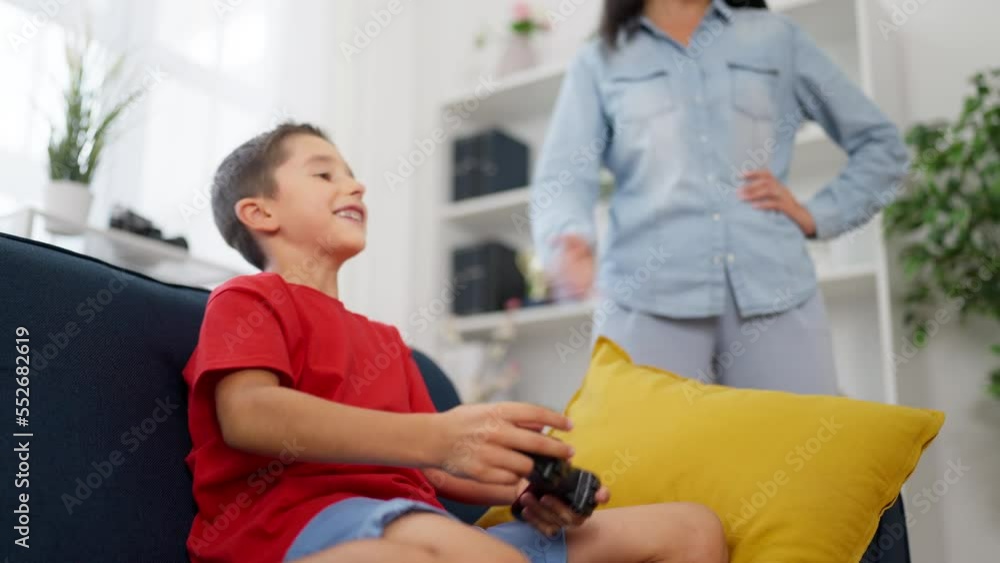 Mother arguing with son who keeps playing video game instead of doing ...