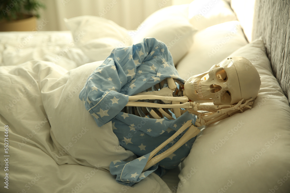 Human skeleton in pajamas lying on bed indoors Stock Photo | Adobe Stock