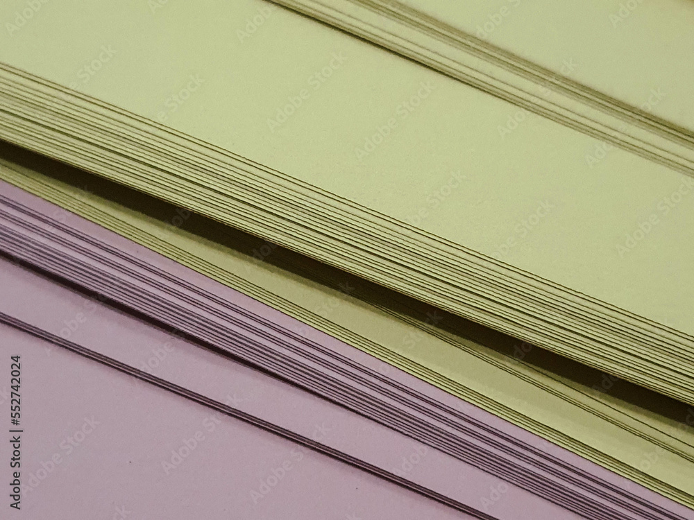 Stacks of yellow and pink HVS papers. Stock Photo | Adobe Stock