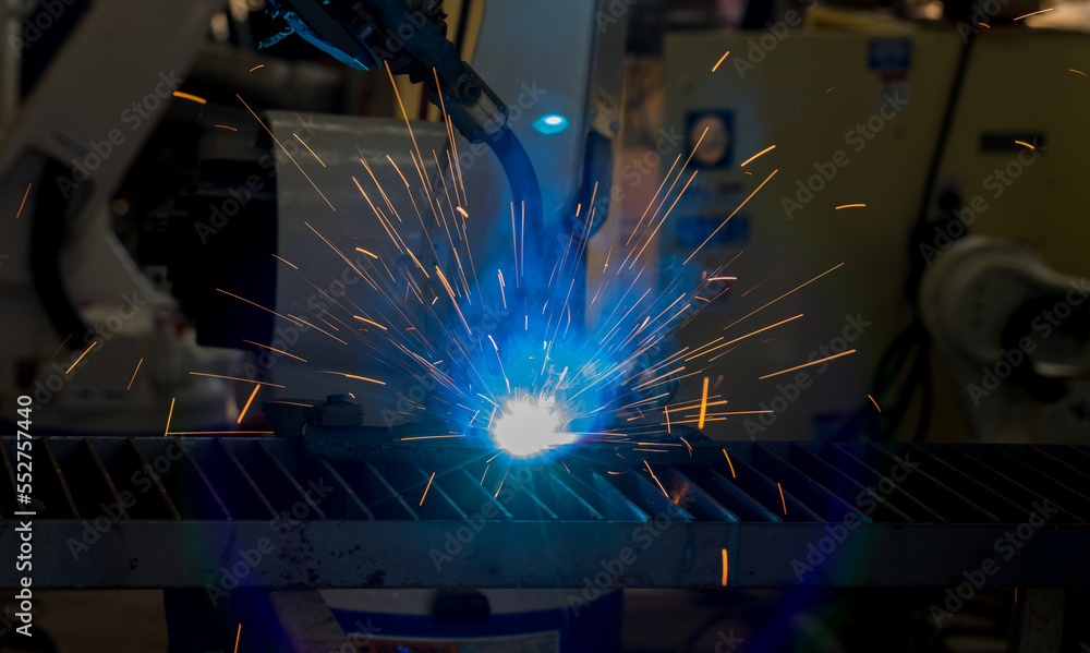 Welding robots movement in factory. Sparks during electric welding. The ...