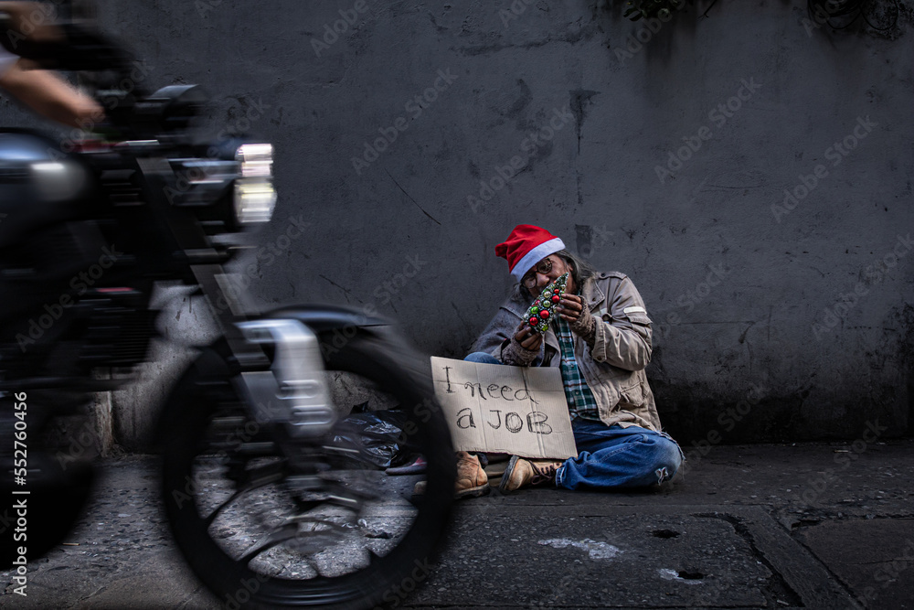 Asian homeless man wearing christmas hat sitting on side of road ...