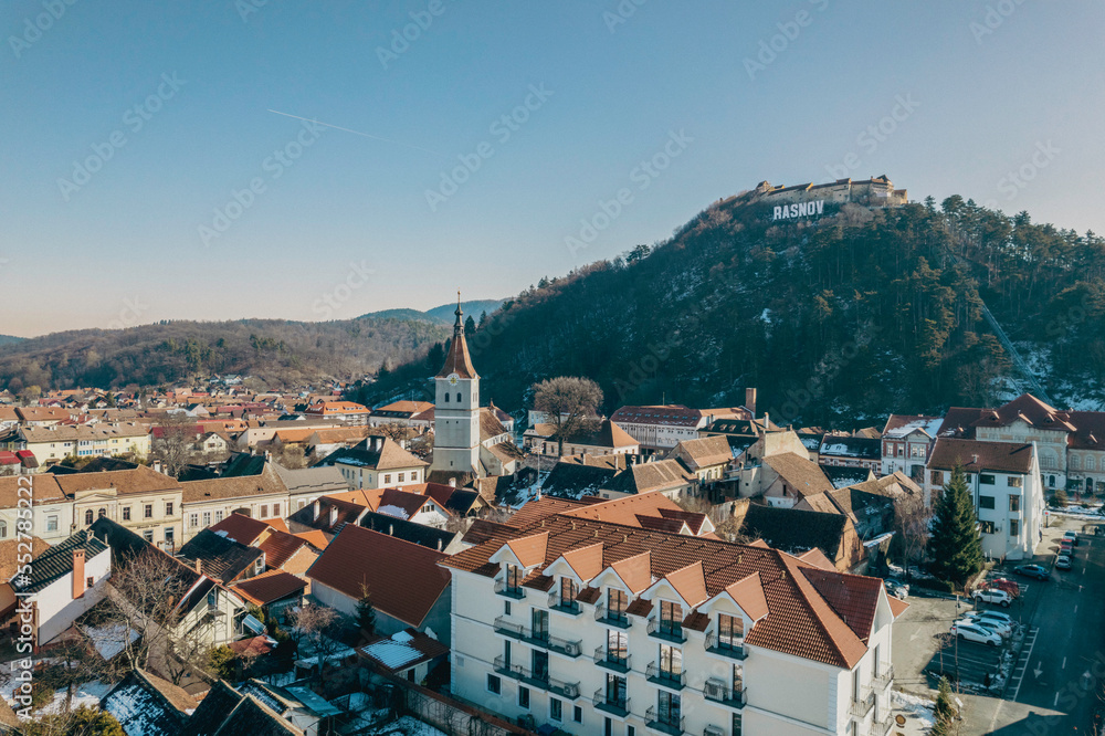 Aerial view of Rasnov, Romania shows that the buildings are styled with ...