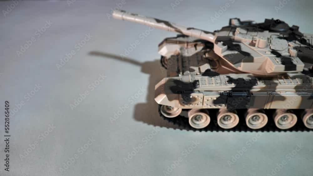Close-up shot of an isolated radio-controlled toy tank that drives ...