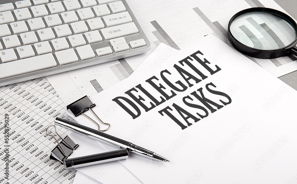 DELEGATE TASKS text on paper with chart and keyboard, business concept ...