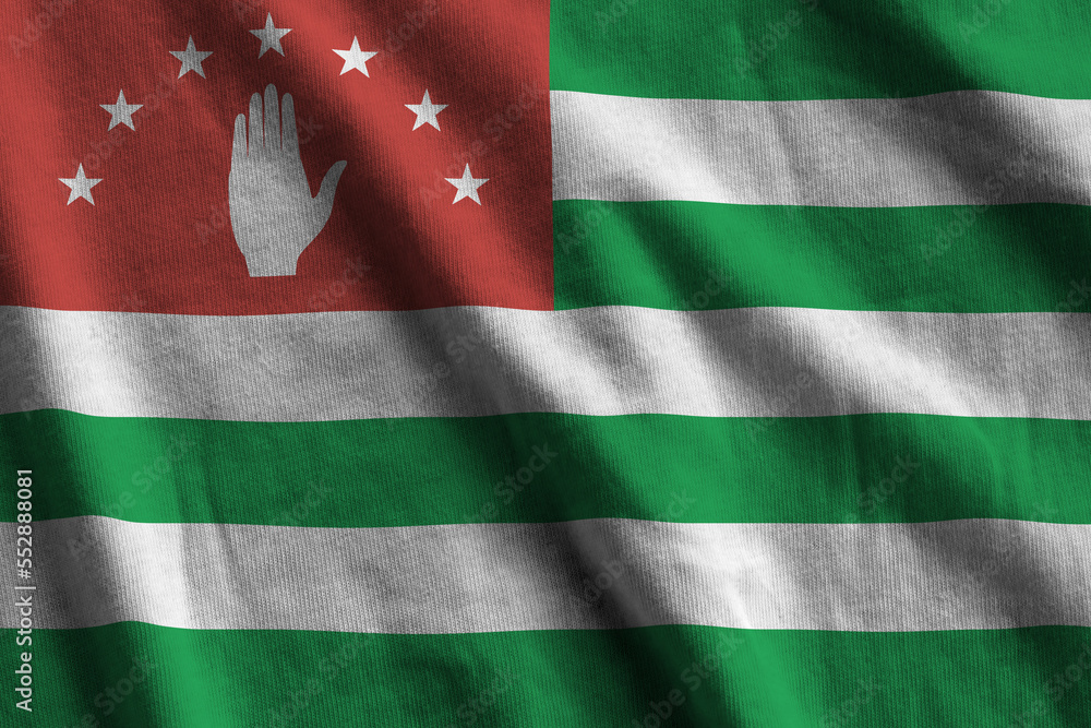 Abkhazia flag with big folds waving close up under the studio light ...