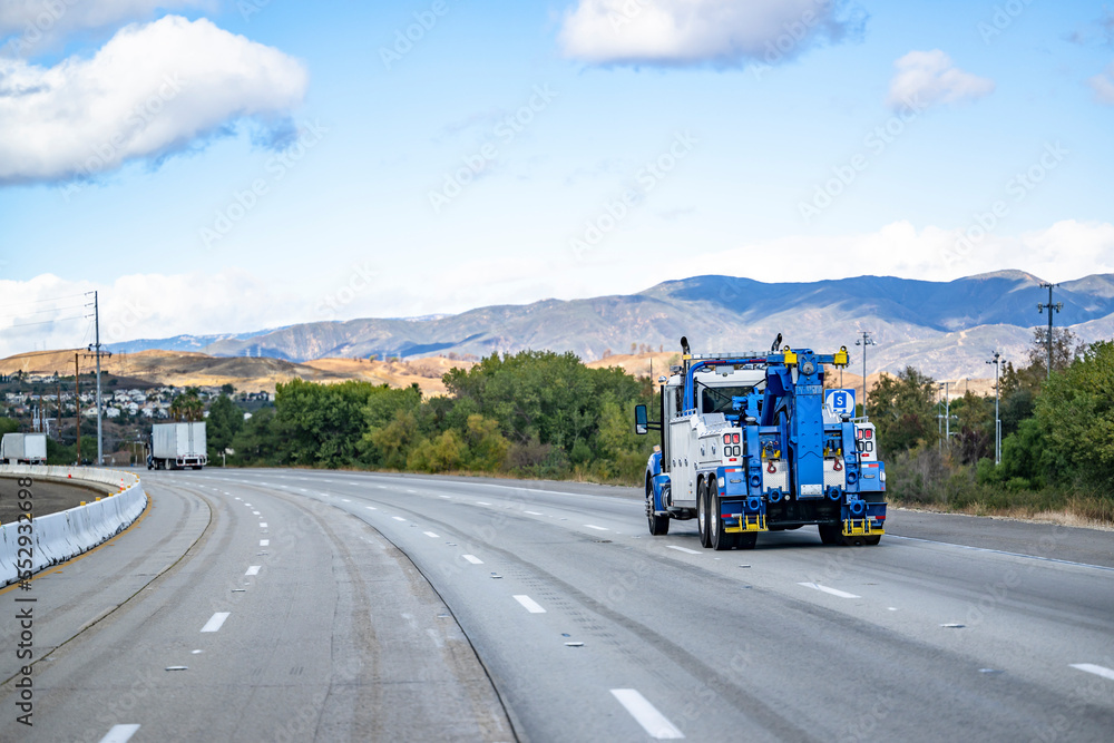 Powerful big rig towing semi truck tractor with lifting boom running on ...