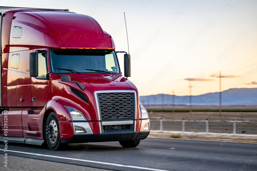 Powerful dark red bonnet big rig semi truck transporting cargo in dry ...