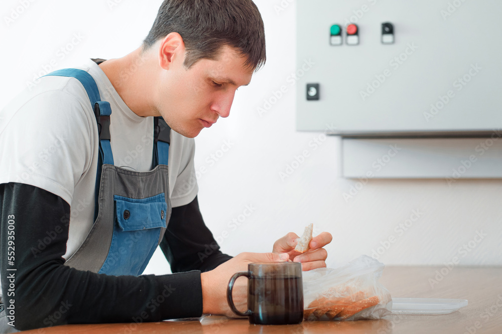 Lunch break. Eating in workplace during work. Caucasian man in work ...