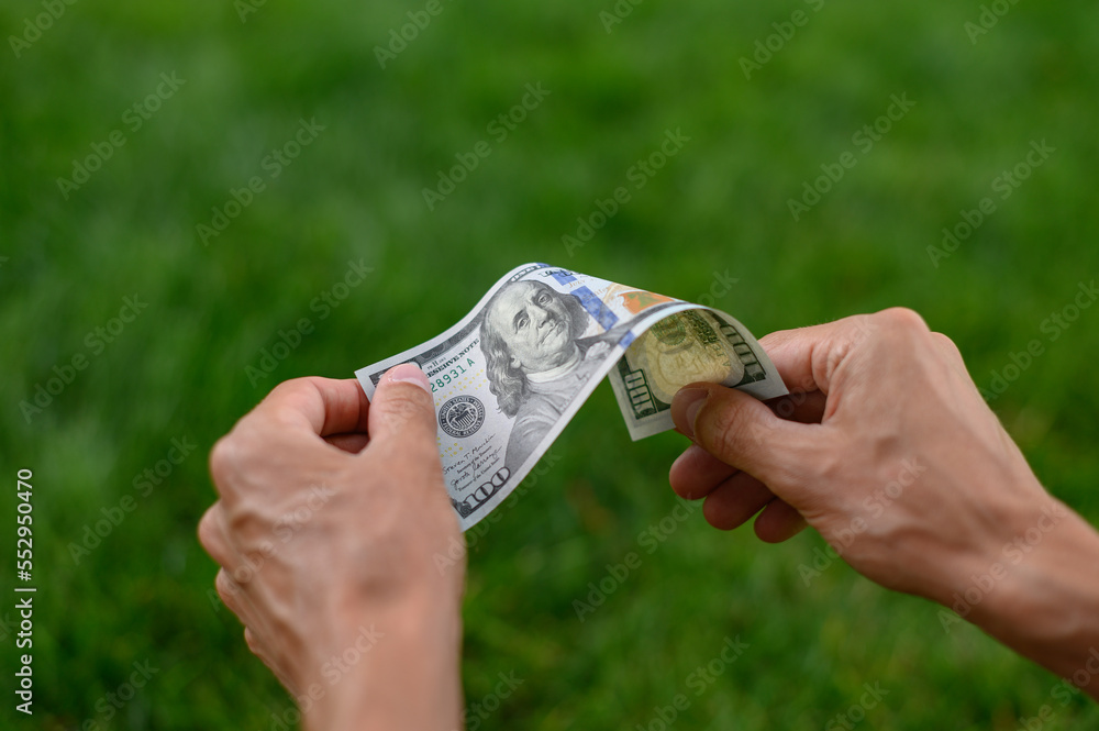 First person top view photo of hands holding fan of Dollar banknotes on ...