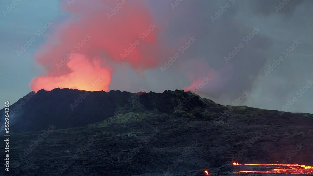 Volcanic eruption. Hot lava. Red smoke over the crater. Lava flow over ...