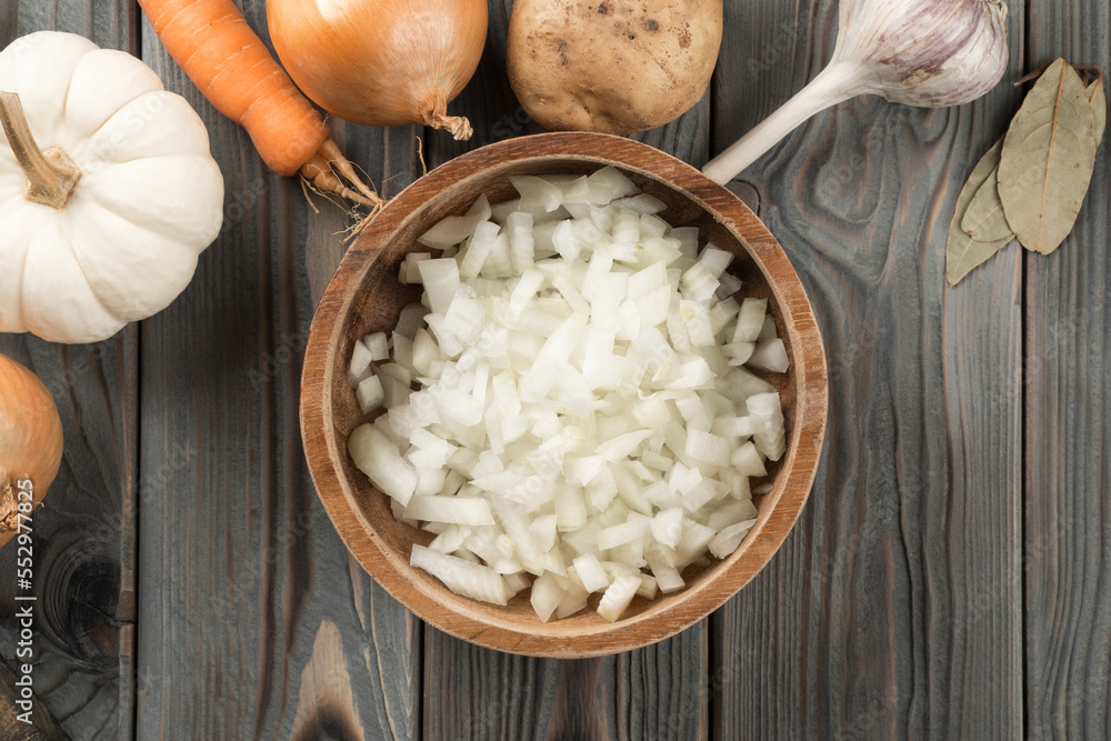 Cut spicy onion into cubes. Bowl full of white diced onion on kitchen ...
