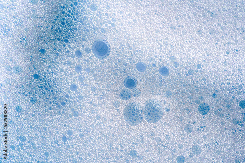 Texture of white foam on blue background. Foam cosmetic product for ...