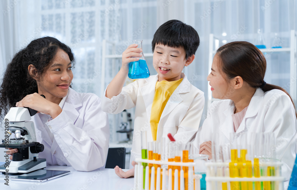 smart young boy enjoys examining chemical laboratory with school ...
