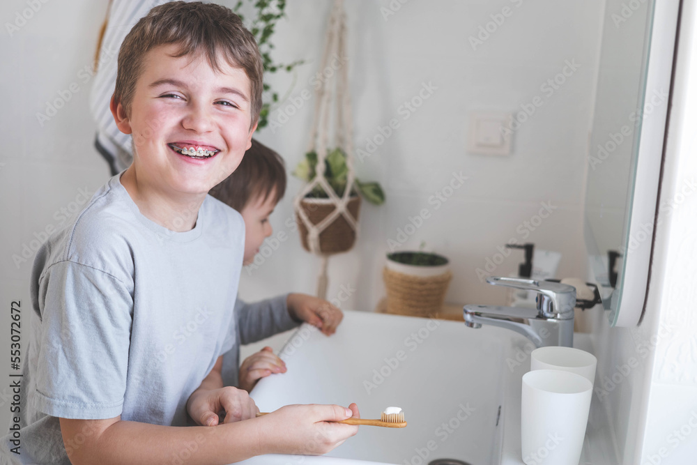 Happy boy child cleaning teeth with braces use wooden eco friendly ...