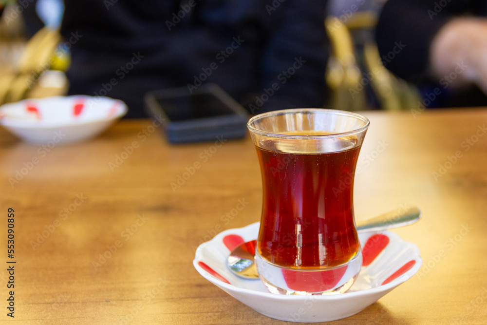 Turkish tea on table served in the traditional way. Tulip-shaped glass ...