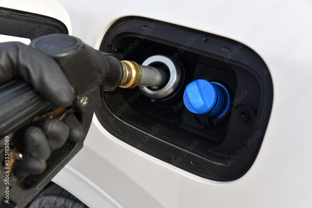 Refueling gun in tank filler. Fuel Nozzle in tank filler. Fuel pump in ...