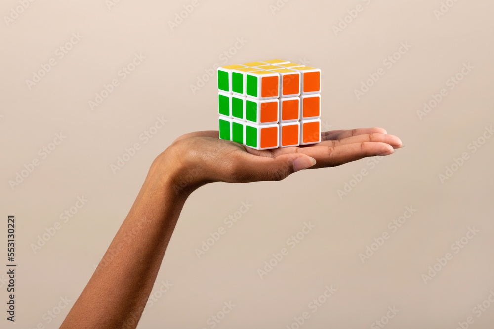 Black female hand showing solved Rubiks cube Stock Photo | Adobe Stock