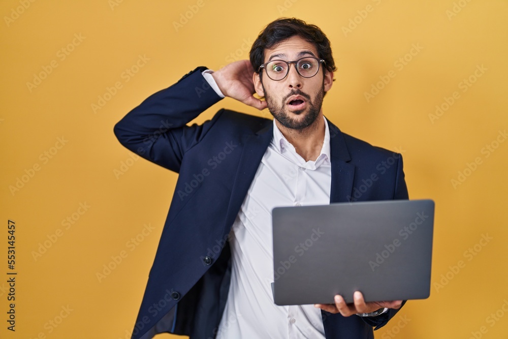 Handsome latin man working using computer laptop crazy and scared with ...