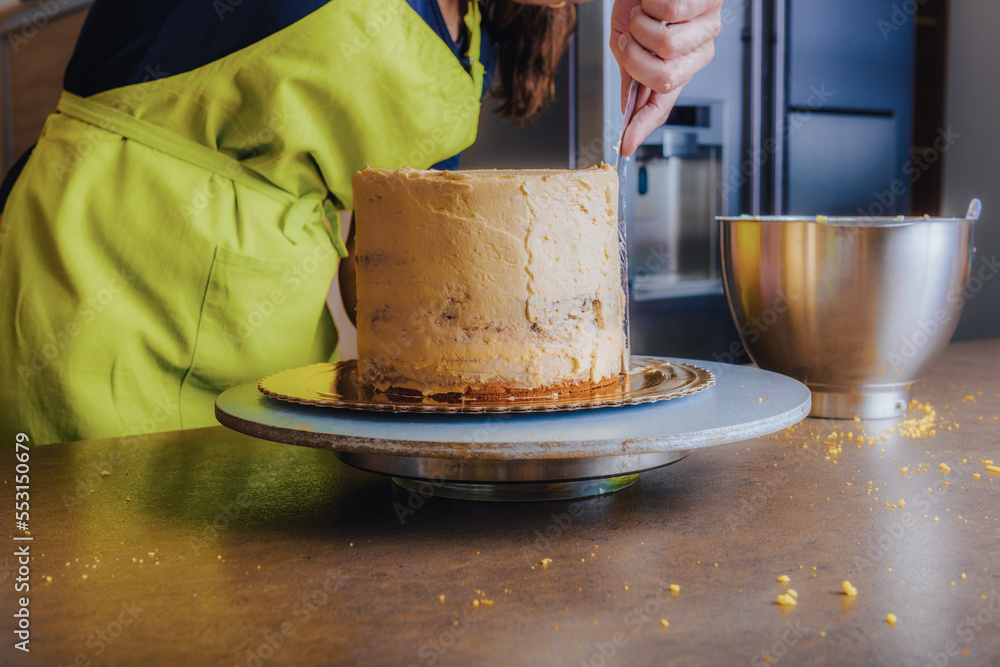 Photo Unrecognisable woman decorating a delicious layered sponge cake ...