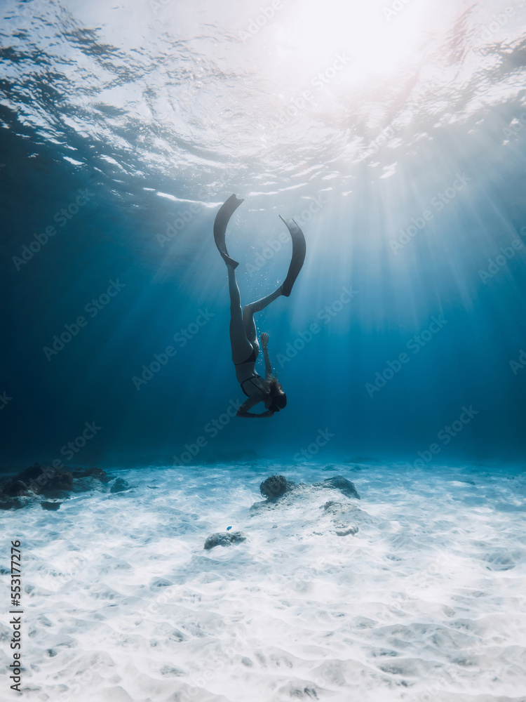 Freediver with fins dive to sea bottom. Freediving in blue ocean with ...