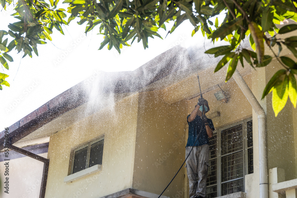 Worker using high pressure water jet spray gun to wash and clean dirt ...