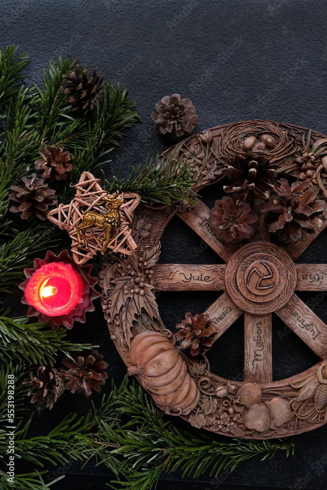 wiccan altar with Wheel of the year, candle, amulet deer, cones, fir ...