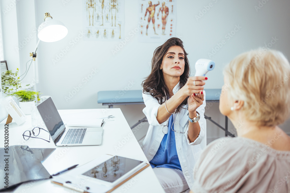 Foto Stock Medical doctor checking senior patient temperature with ...