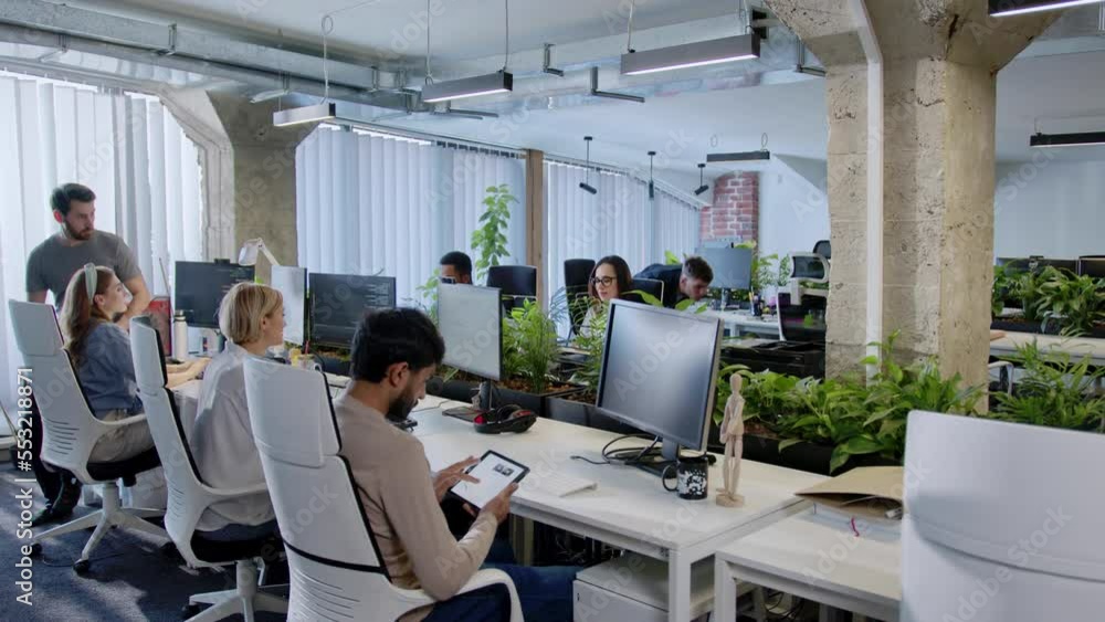 Successful young professional people working in modern IT company using ...