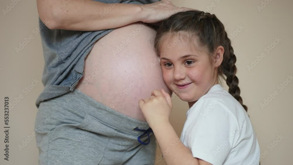 little girl hugs her mother belly. happy family kid pregnancy newborn ...