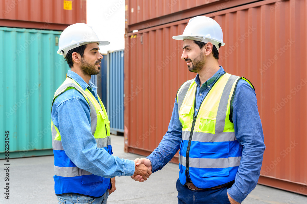 Two engineer container cargo wearing white hardhat and safety vests in ...