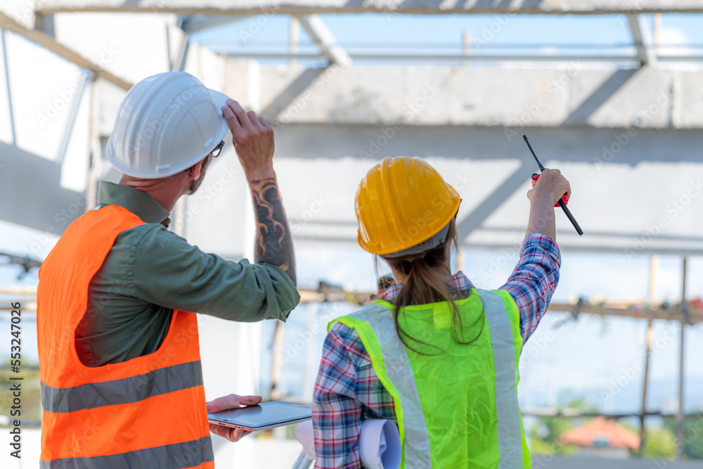 Structural engineer and foreman worker with blueprints discuss, plan ...