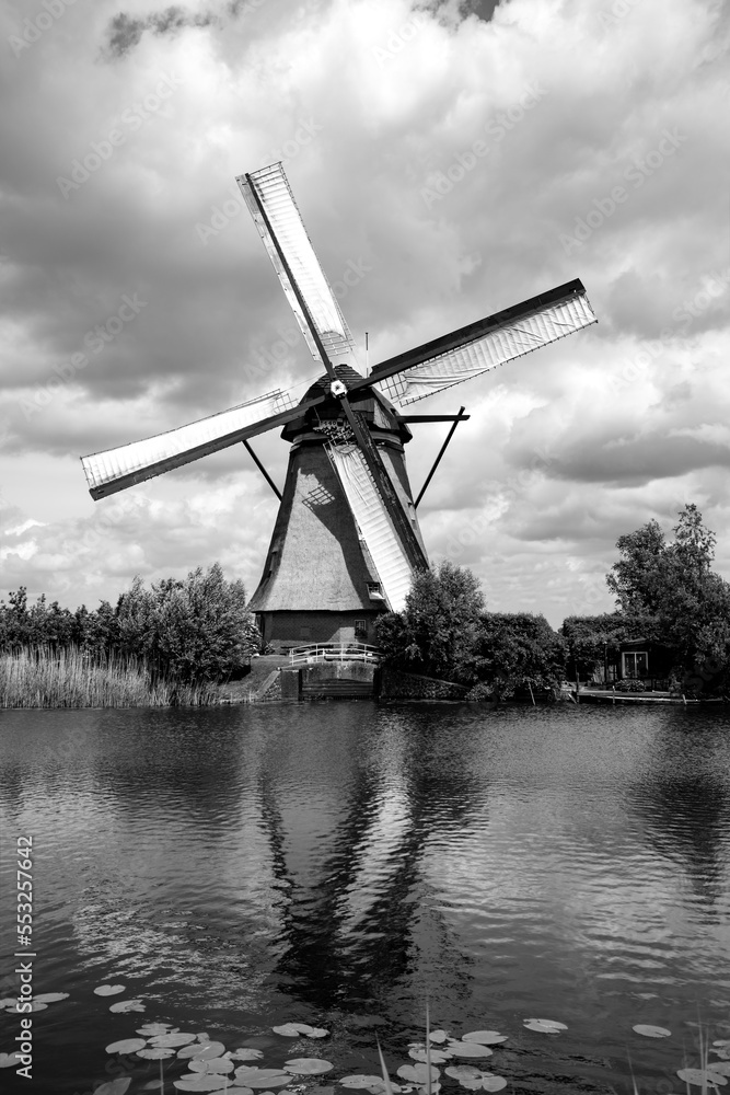 Vintage Windmill in “Kinderdijk“, a famous Dutch tourist attraction and ...