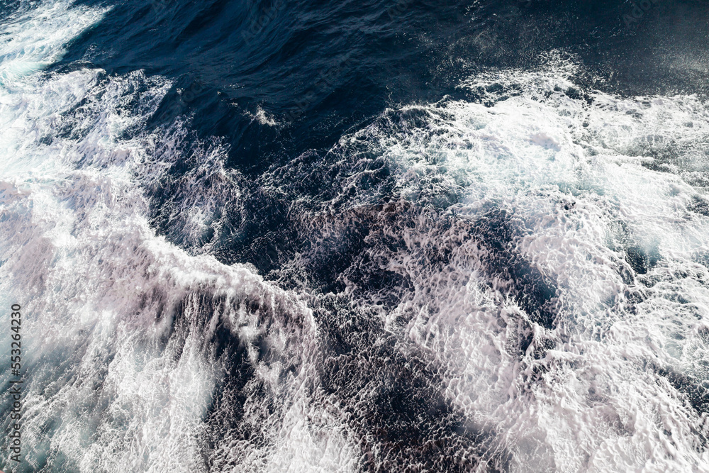 Rushing water in the open sea. Blue water background with white foam ...