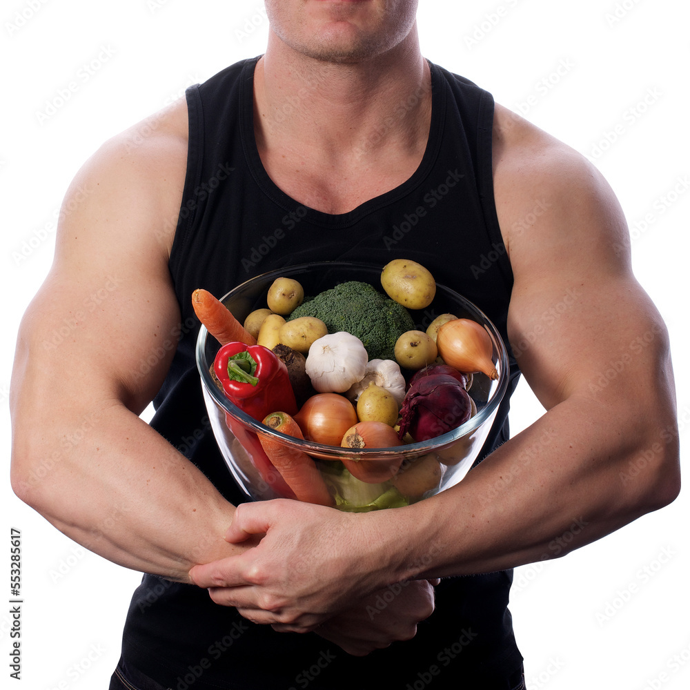 Strong, fit, muscular man holding a bowl of mixed vegetables in front ...